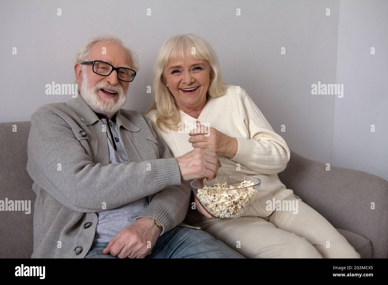 Couple eating popcorn on sofa hi-res stock photography and images - Alamy