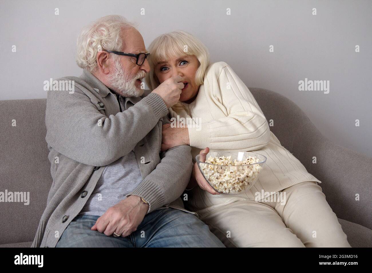 Couple eating popcorn on sofa hi-res stock photography and images - Alamy