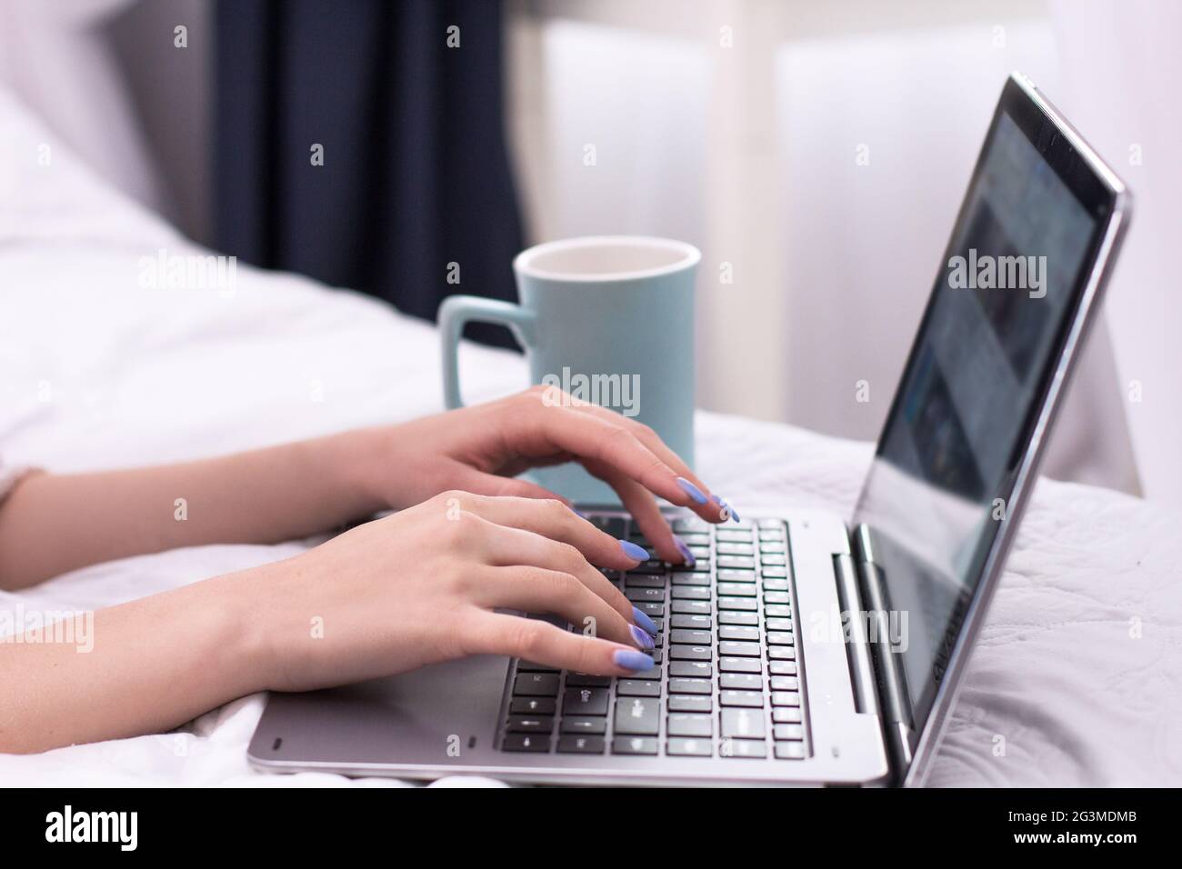 Young lady with laptop in bed Stock Photo - Alamy