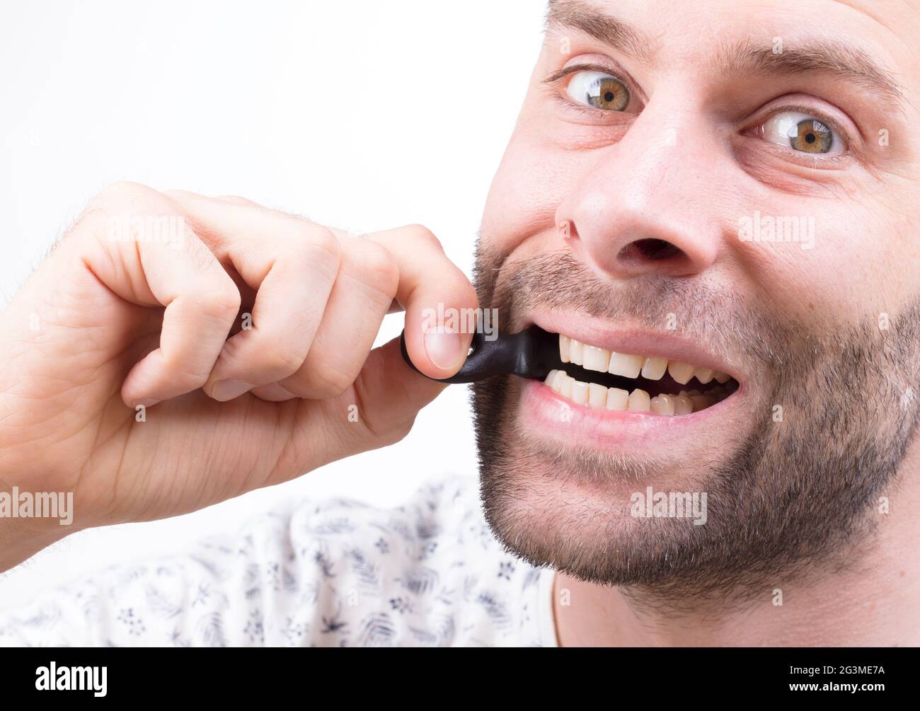 Man eating typicaly dutch candy called 'Dropsleutel' (candy key Stock ...