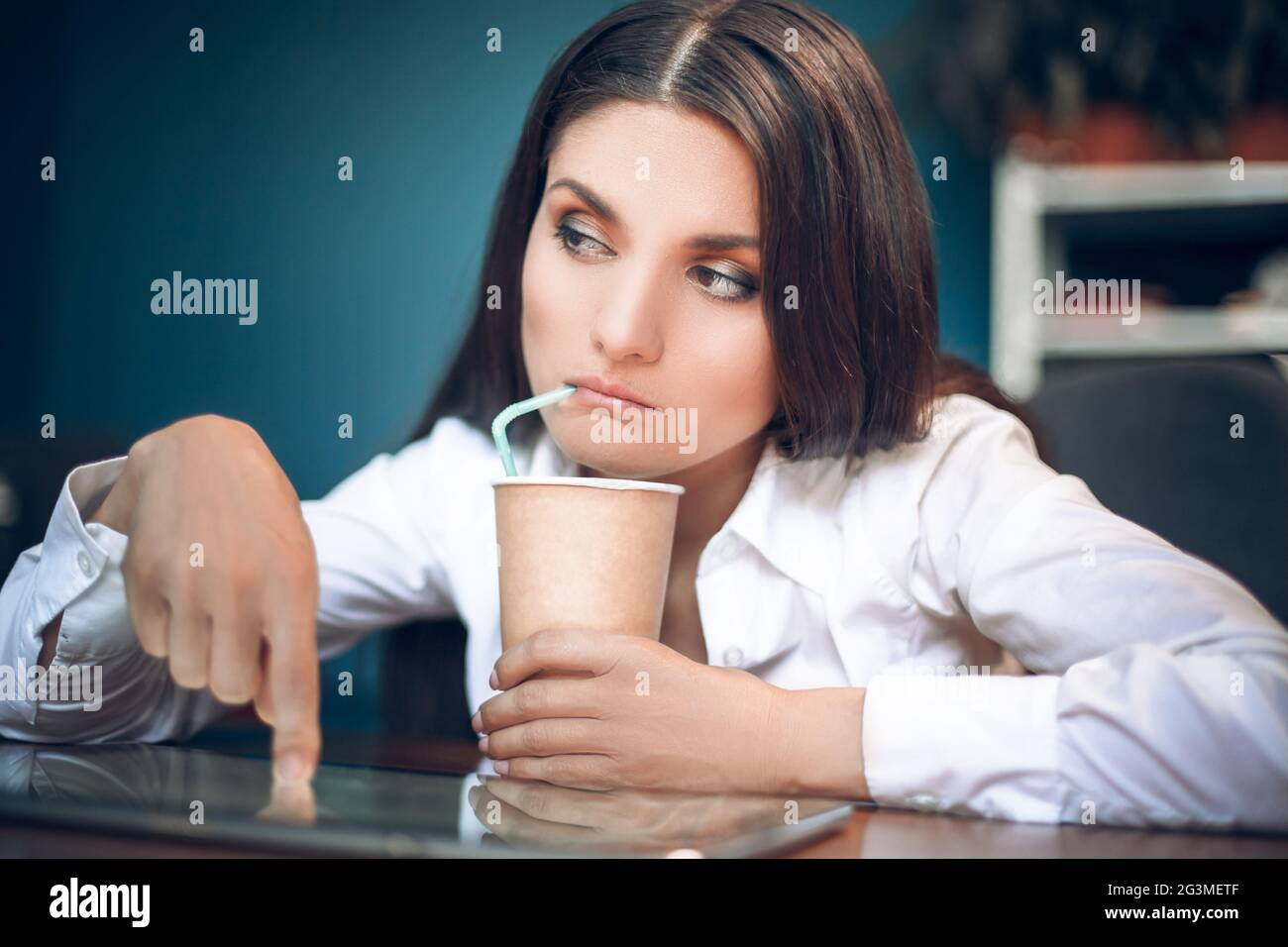Tired lady drinking from straw Stock Photo - Alamy