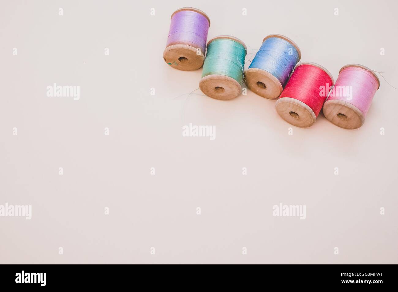 Colorful sewing threads on a light background with free space for text ...
