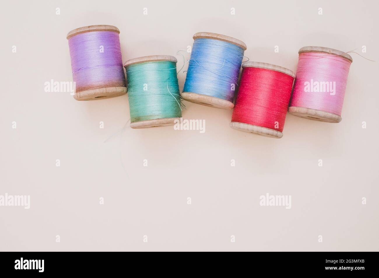 Colorful sewing threads on a light background with free space for text ...
