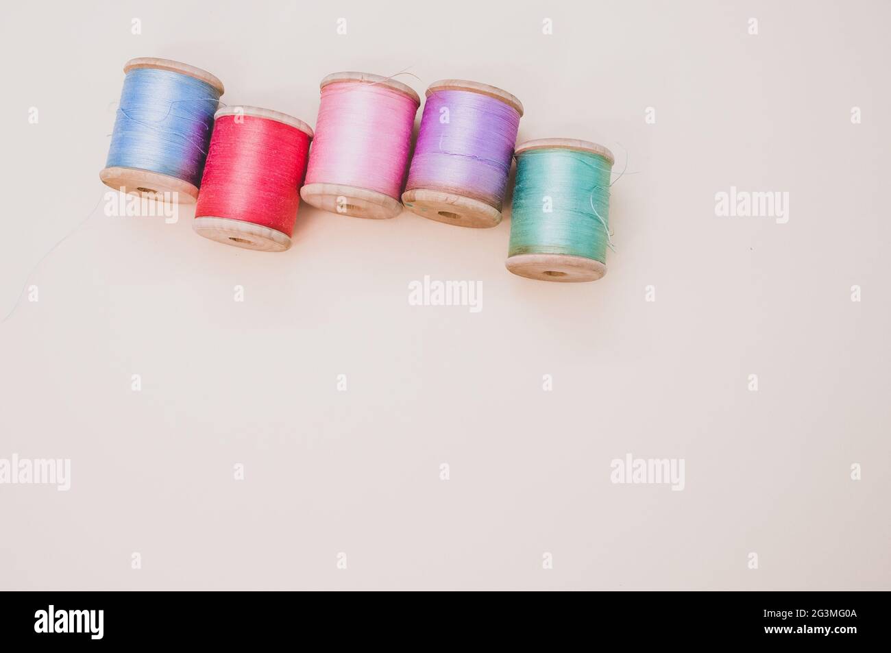 Colorful sewing threads on a light background with free space for text ...