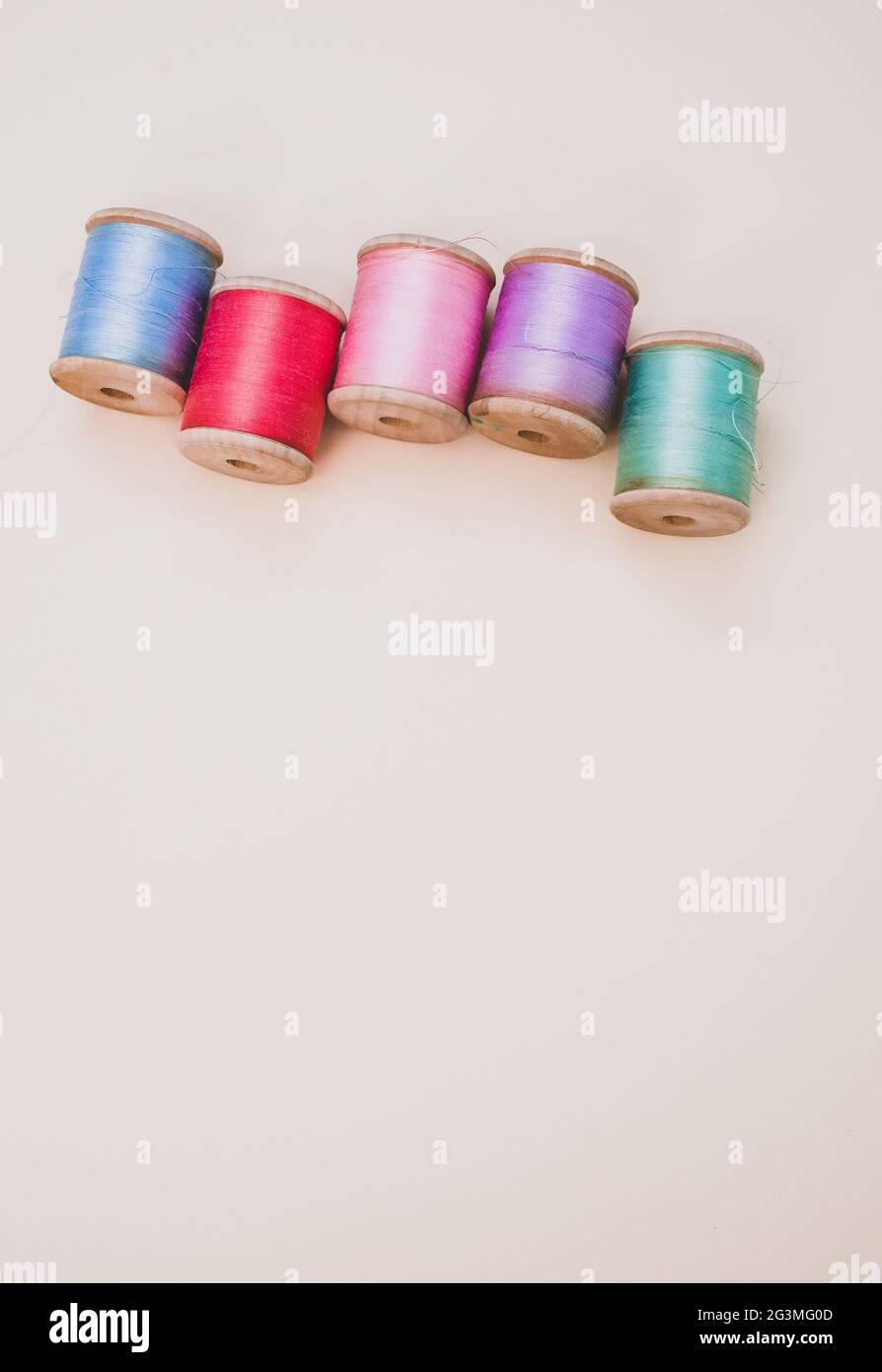 Colorful sewing threads on a light background with free space for text ...