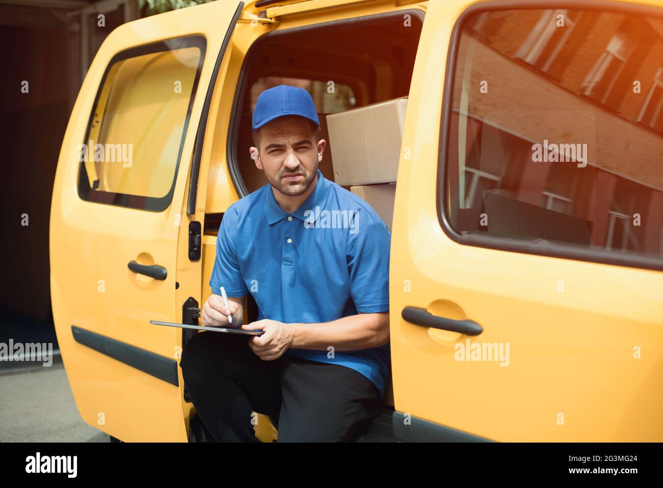 Delivery man driving his van Stock Photo - Alamy