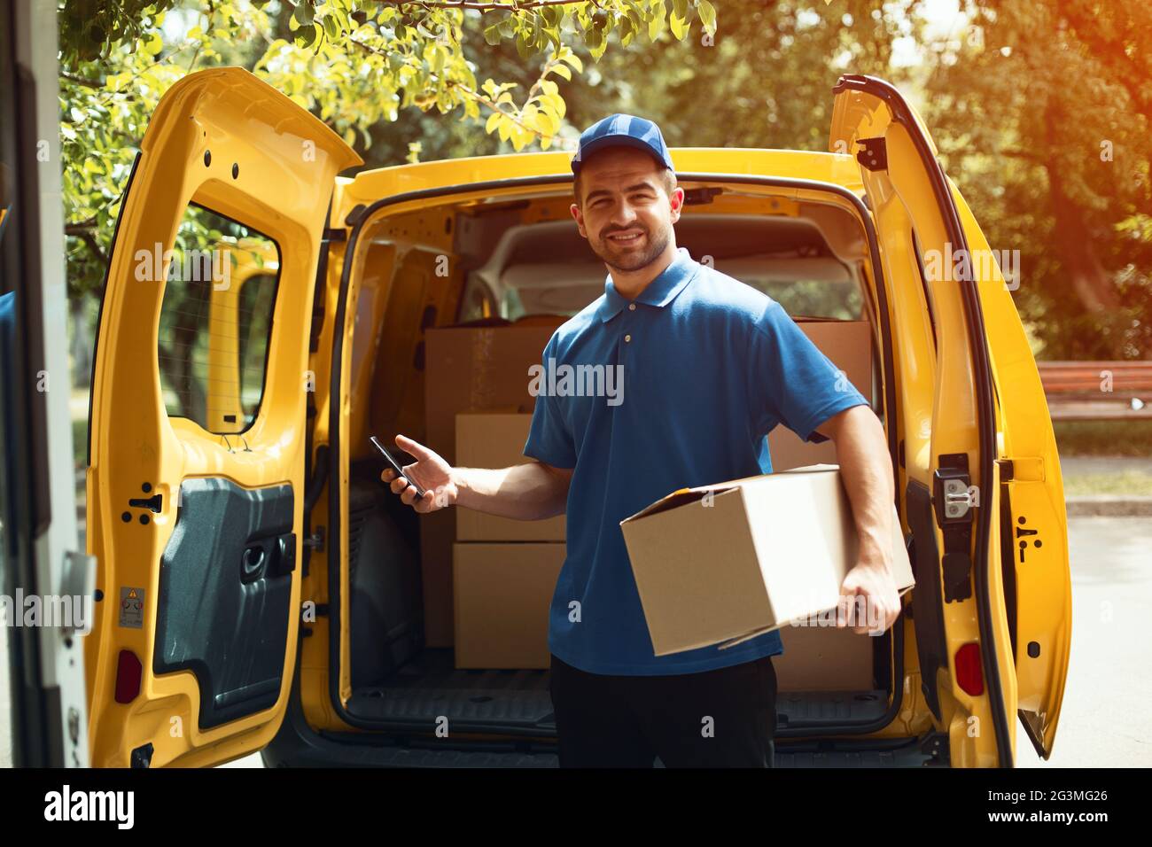Delivery guy holding package Stock Photo - Alamy