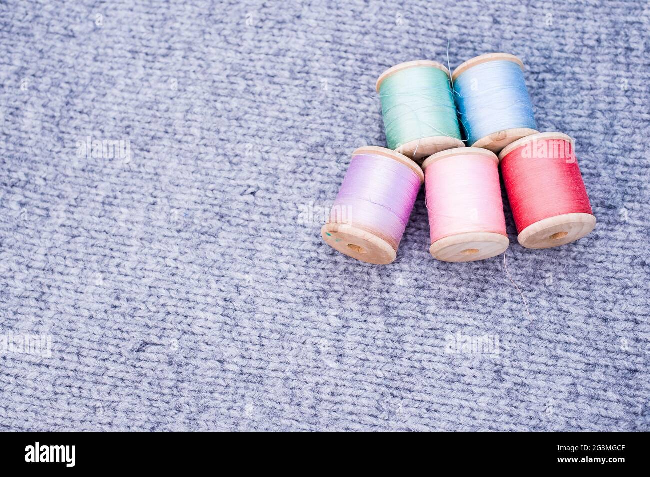 Colorful sewing threads on a grey fabric with free space for text Stock ...