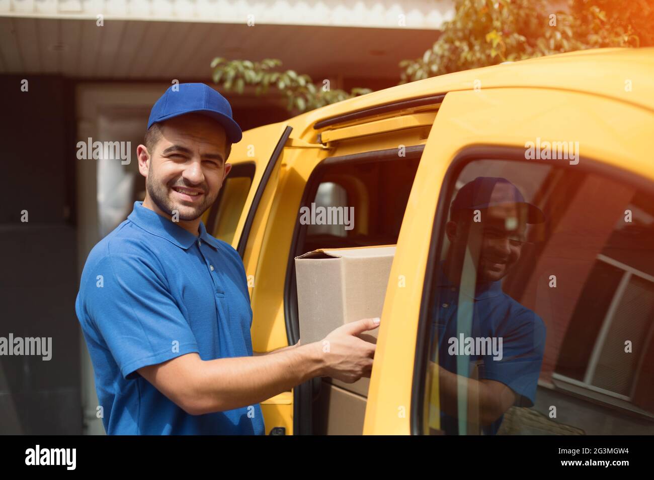 Delivery guy holding package Stock Photo - Alamy