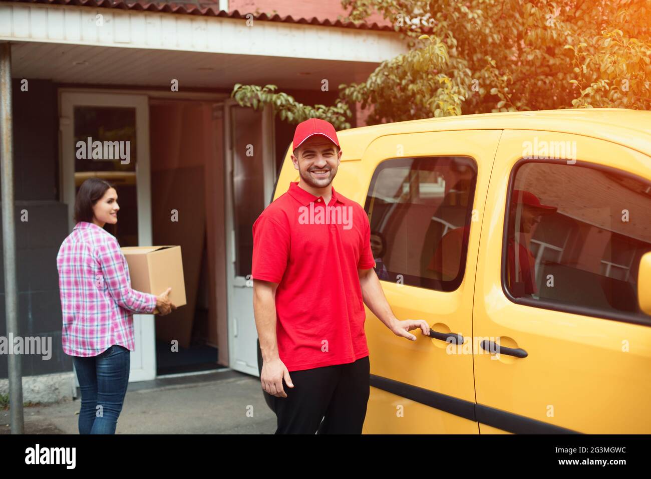 Delivery man handing package box Stock Photo - Alamy