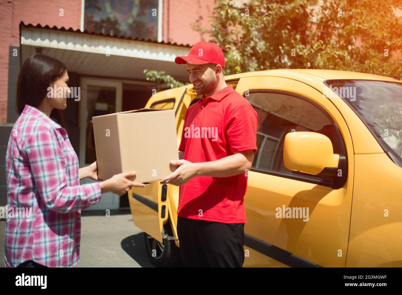 Delivery man handing package box Stock Photo - Alamy