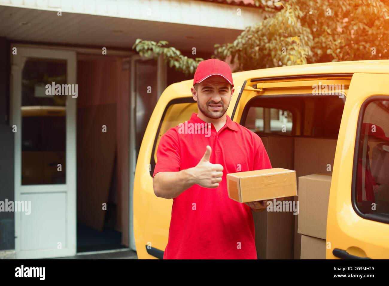 Delivery guy holding package Stock Photo - Alamy
