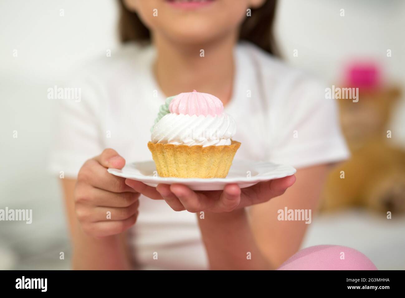 Cute girl eating cupcake Stock Photo - Alamy