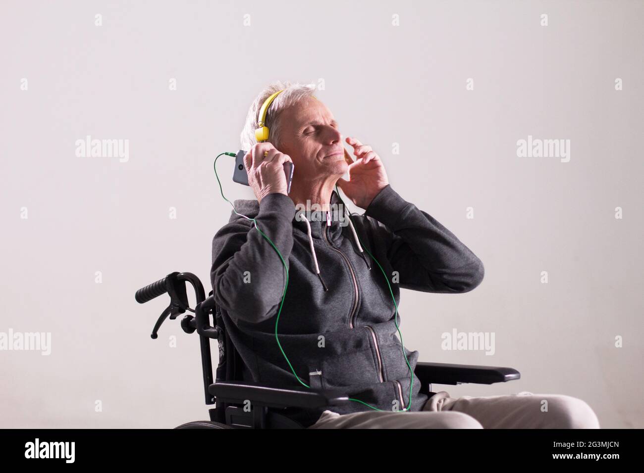 Disabled man listening to music in wheechair Stock Photo - Alamy