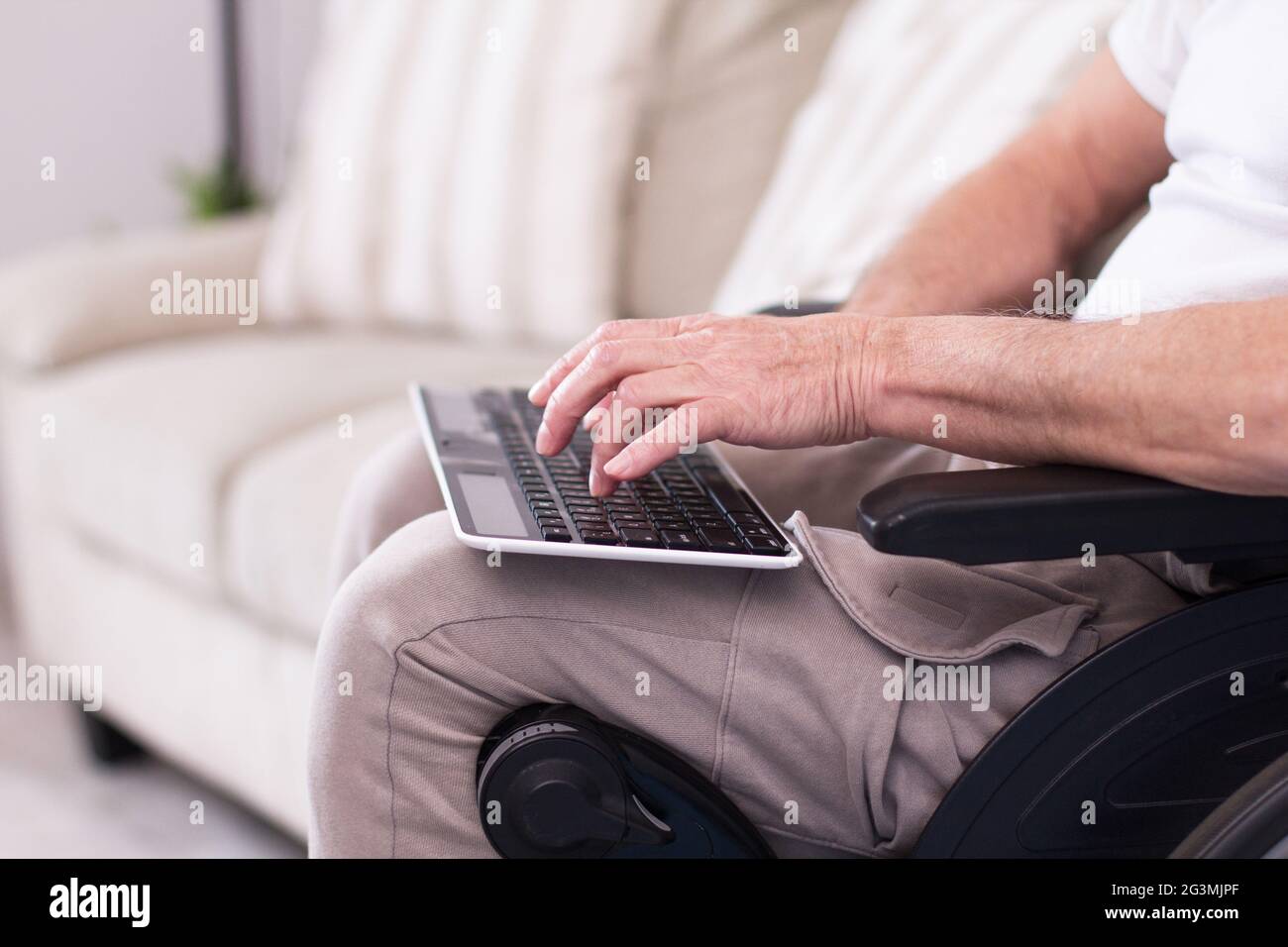 Disabled man typing on keyboard Stock Photo - Alamy