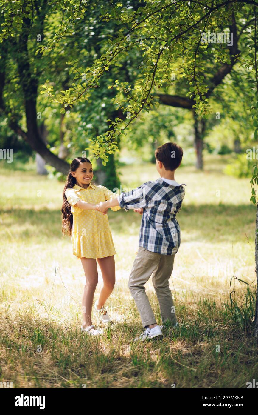 Little boy and girl spinning around Stock Photo - Alamy