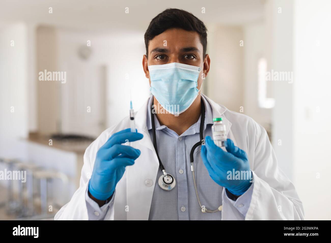 Portrait of hispanic male doctor wearing face mask holding covid 19 ...