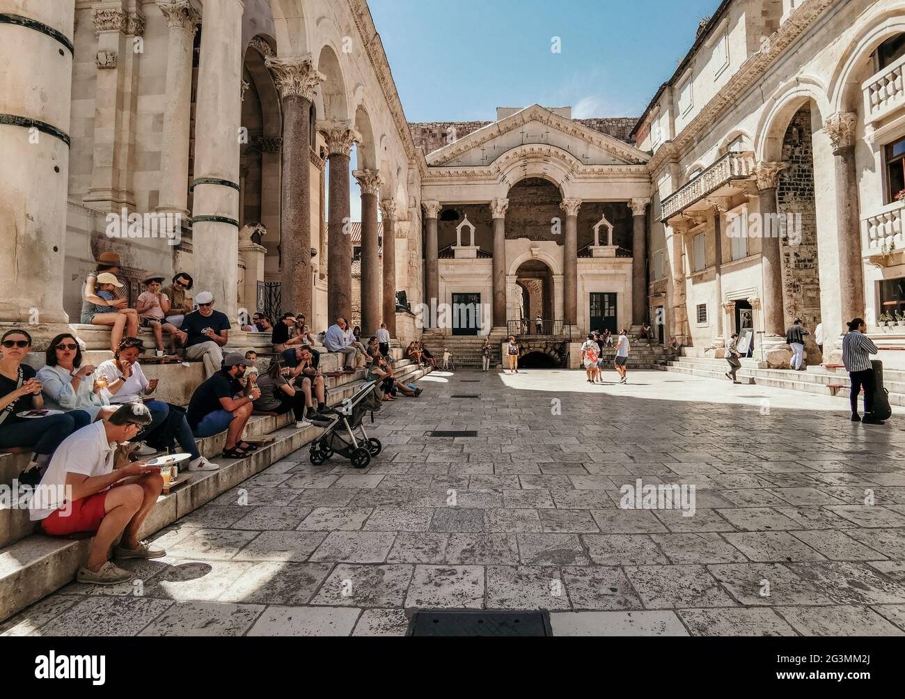 SPLIT, CROATIA - Jun 13, 2021: Tourists sitting on stairs inside ...