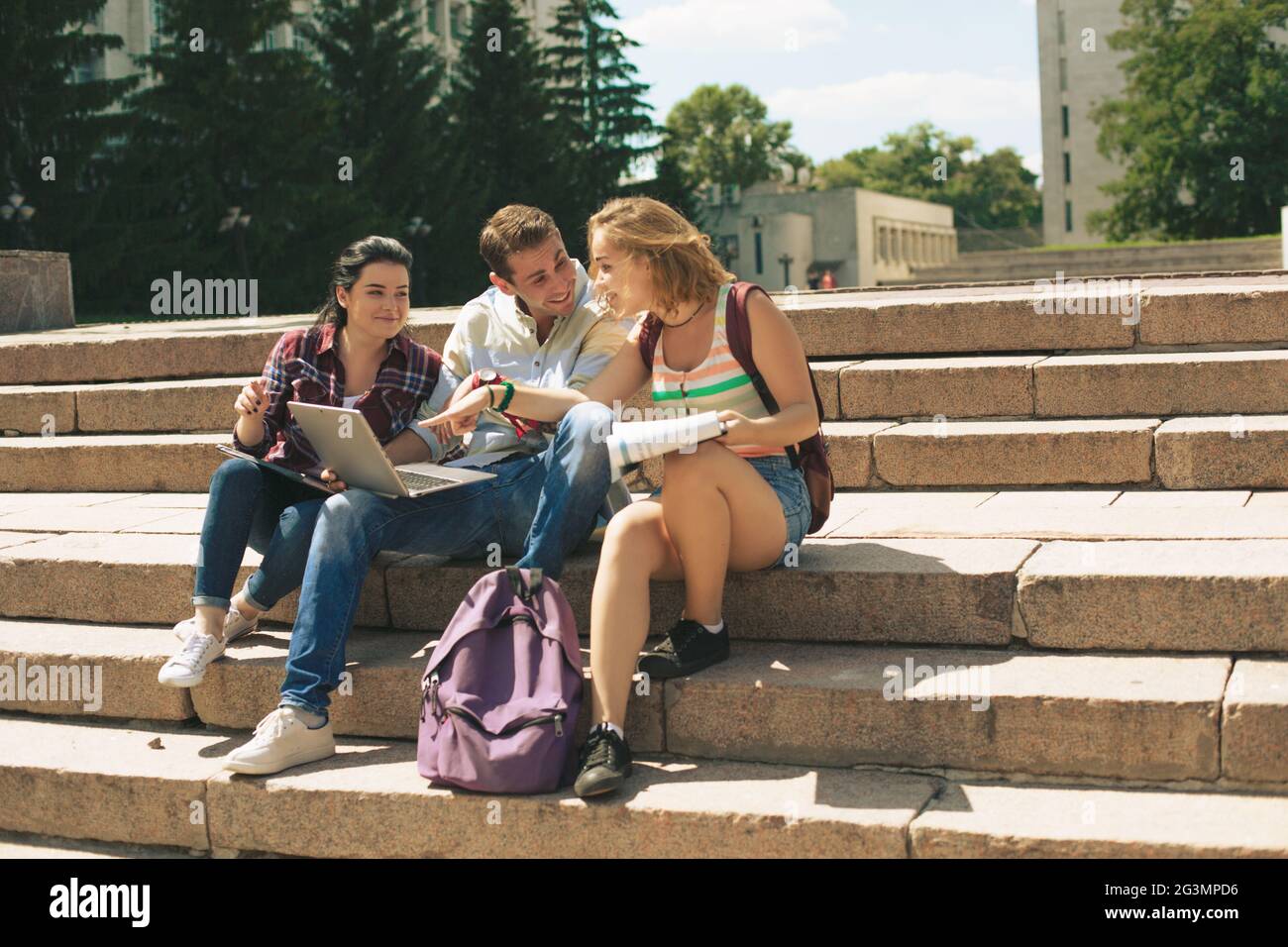 Group of three students sitting on stairs Stock Photo - Alamy