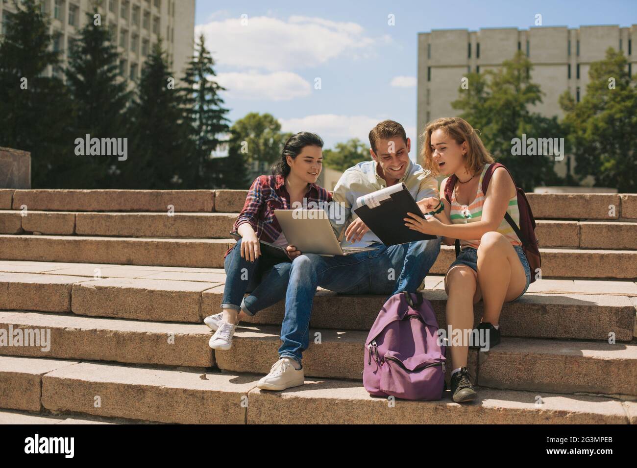Group of three students sitting on stairs Stock Photo - Alamy