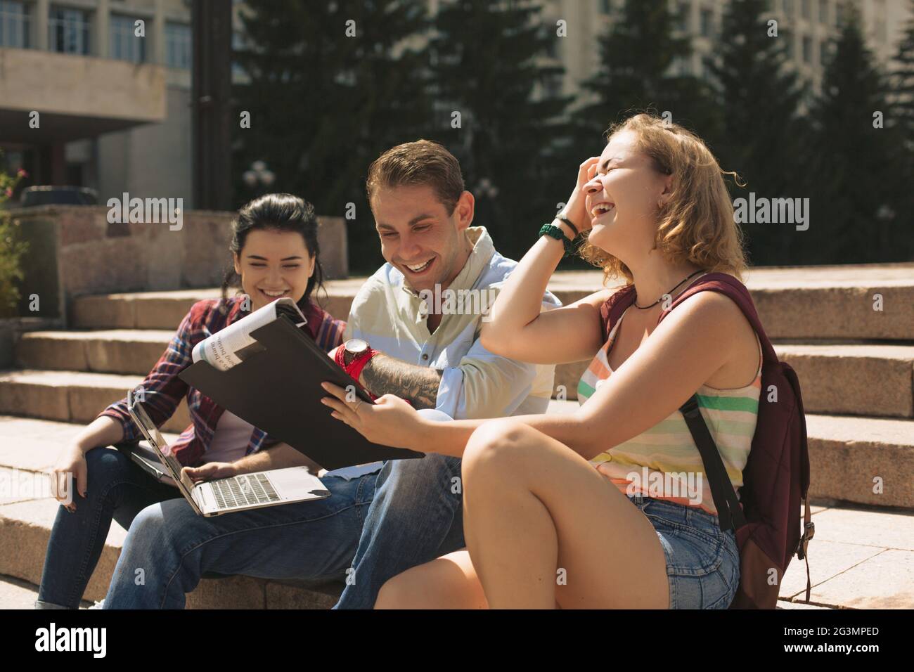Group of three students sitting on stairs Stock Photo - Alamy
