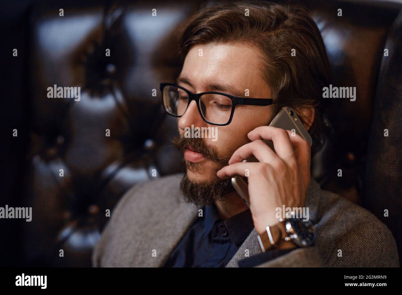 The man in the chair talking on the phone Stock Photo - Alamy