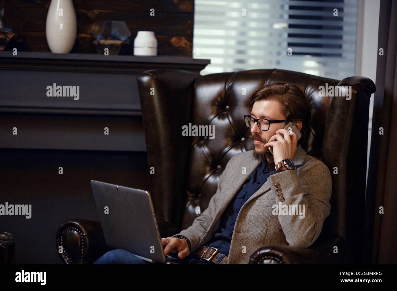 The man in the chair talking on the phone Stock Photo - Alamy