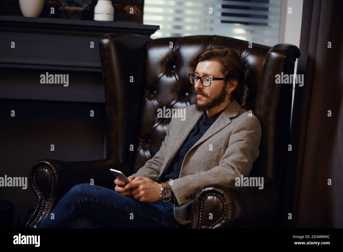 The man in the chair with phone Stock Photo - Alamy