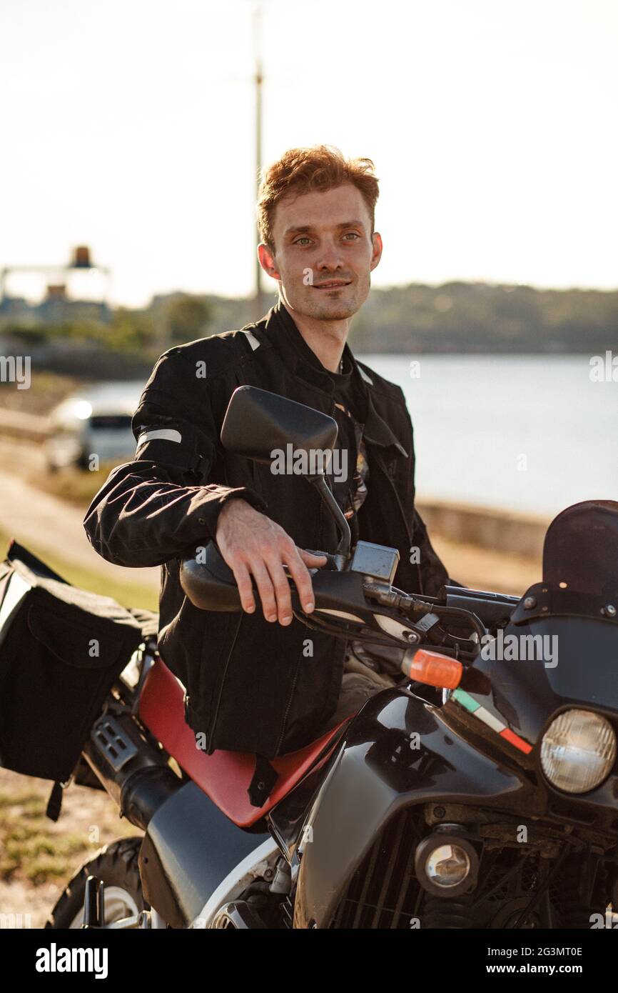 Handsome motorcyclist sitting on the bike Stock Photo - Alamy