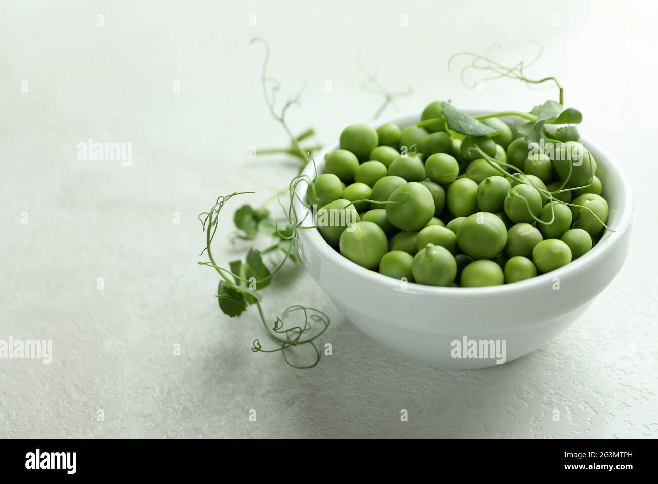 Bowl with pea seeds on white textured background Stock Photo - Alamy