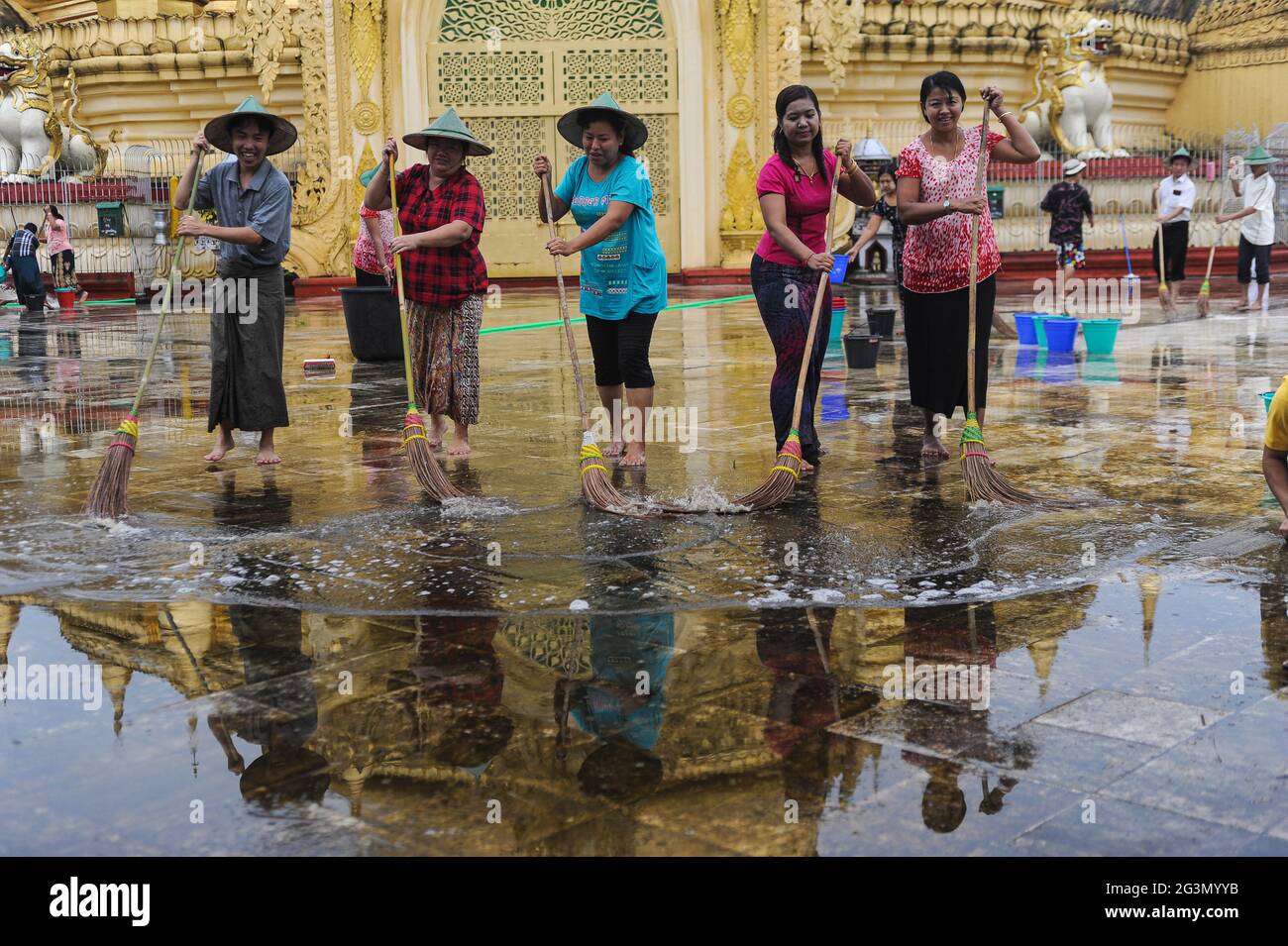 "25.08.2013, Yangon, , Myanmar - A group of locals scrub and clean the ...