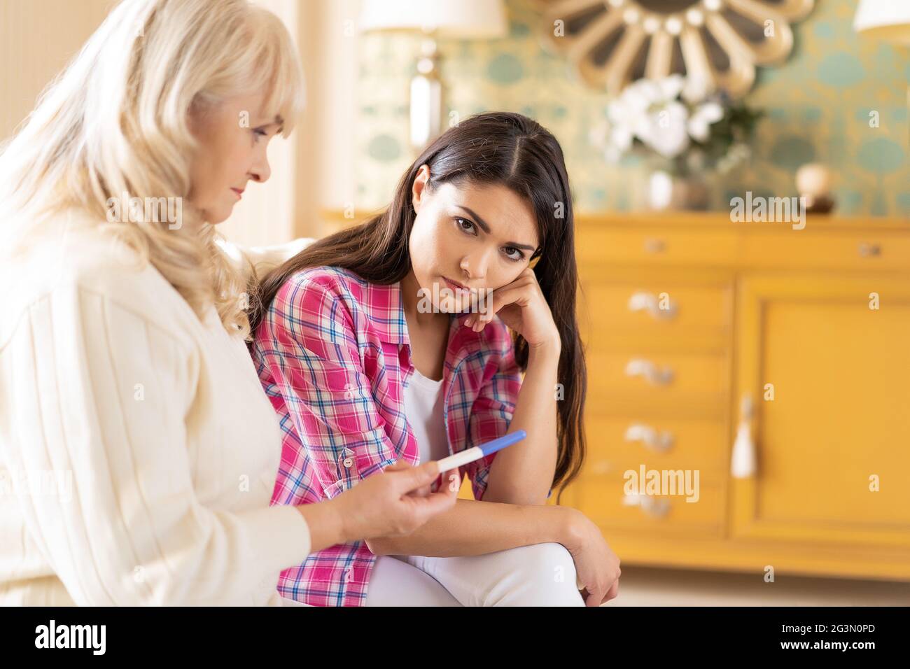 Mother comforts upset daughter with pregnancy test Stock Photo - Alamy