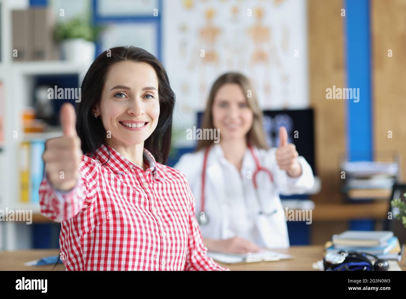 Satisfied healthy smiling young adult female patient showing thumbs up ...
