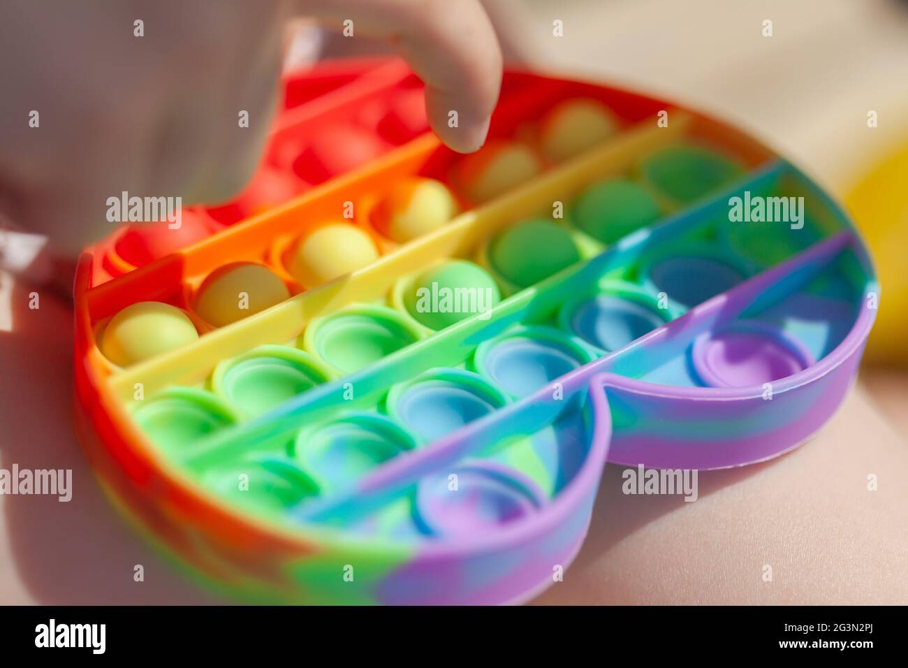 Baby fingers and antistress toy - popit, simple dimple Stock Photo - Alamy