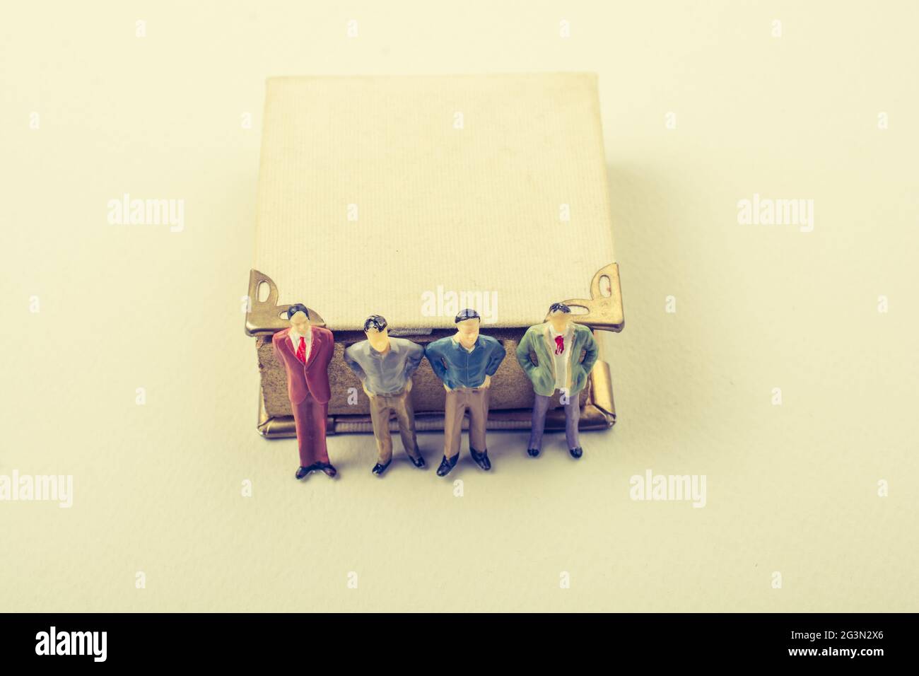 Tiny figurine of men models beside a book Stock Photo - Alamy