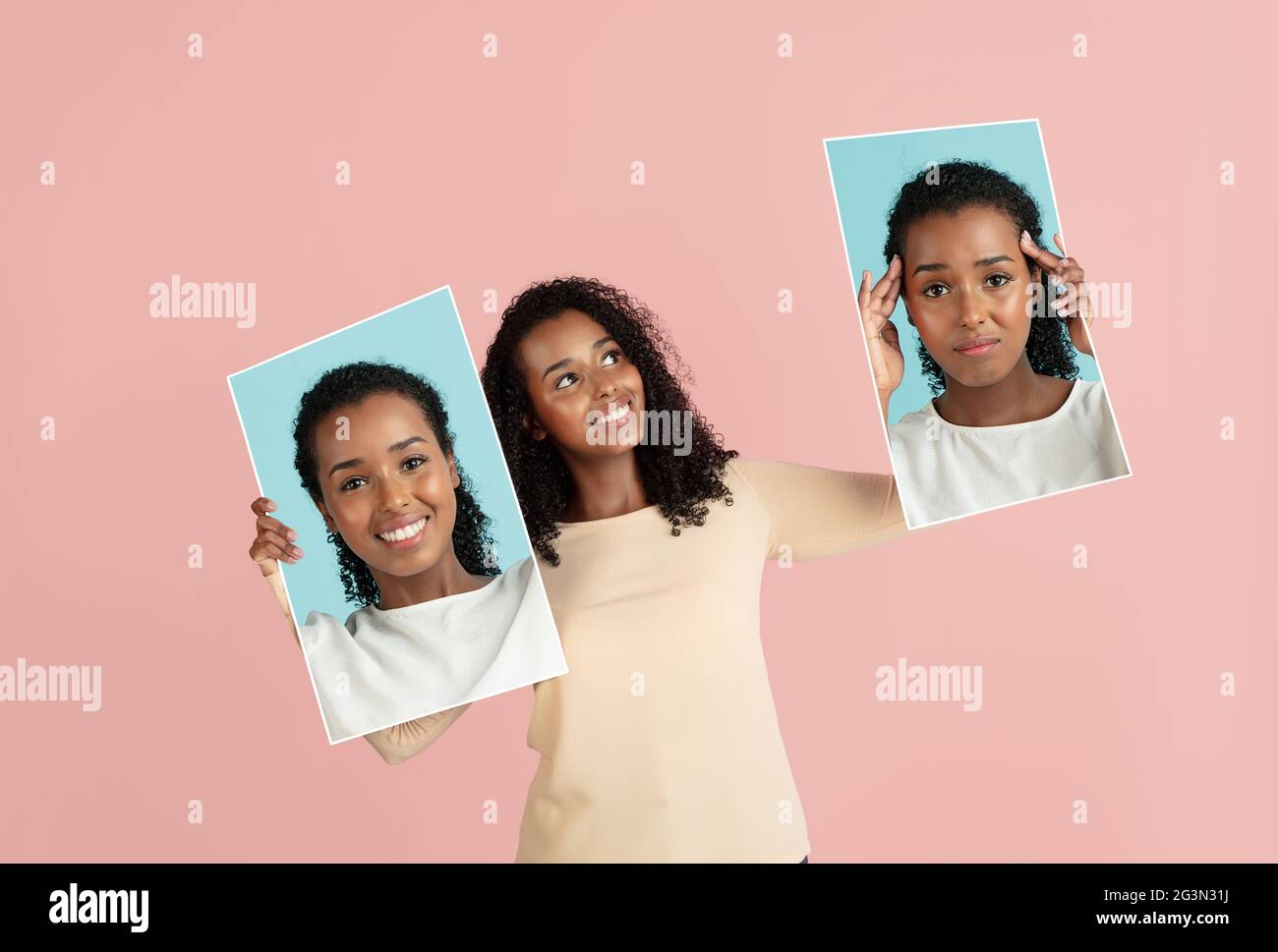 Young attractive girl holding her portraits, pictures isolated on light ...