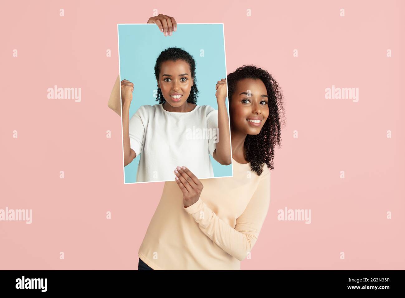 Young attractive girl holding her portrait, photo isolated on light ...
