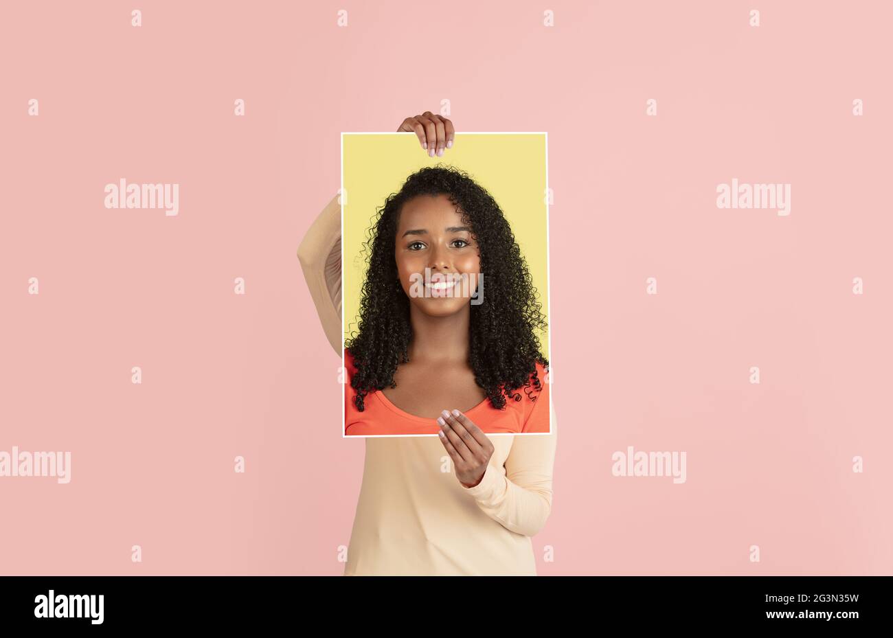 Young attractive girl holding her portrait, photo isolated on light ...