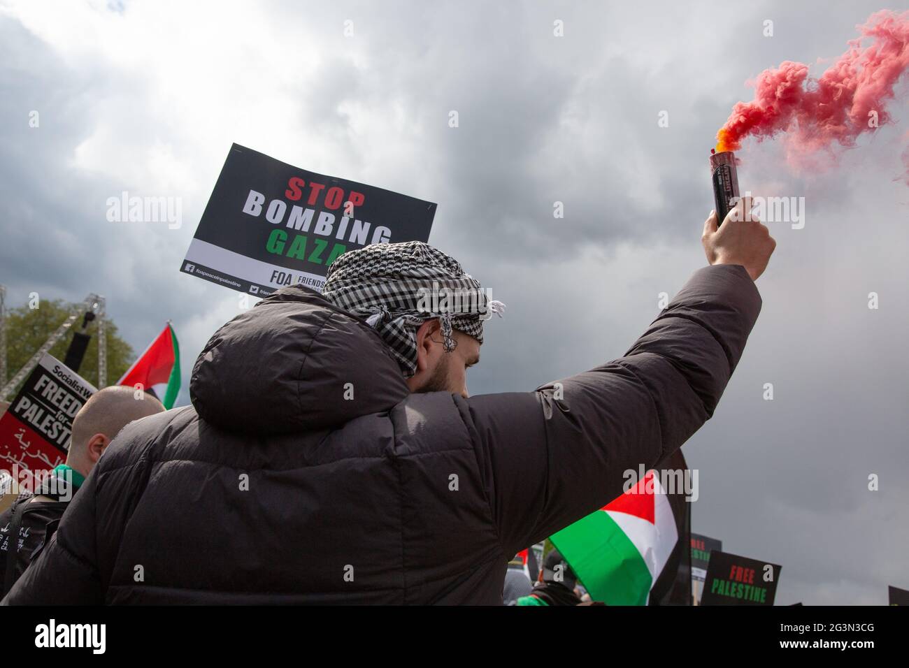 A man hoding a red smoke flare at the Free Palestine Protest, London ...