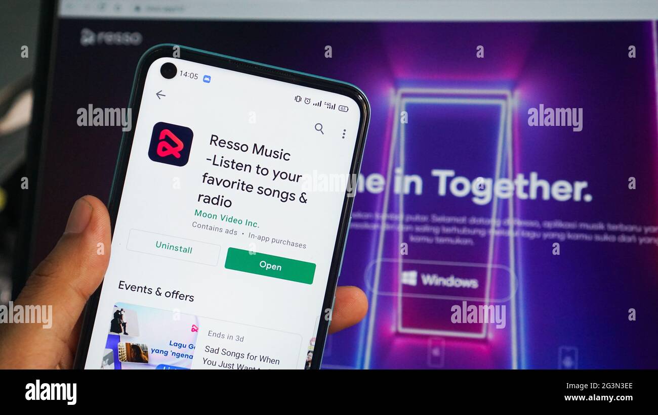 Asian man's hand holds smartphone and opens resso music player app ...