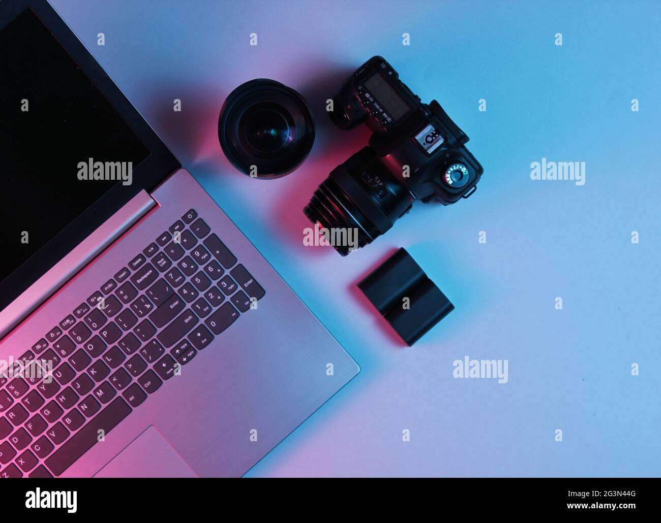 Equipment professional photographer. Laptop, camera, lenses. Neon light ...