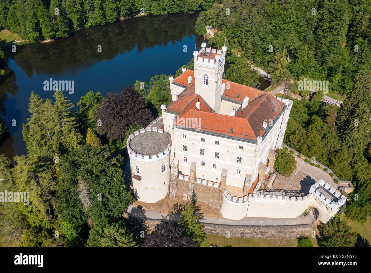 Aerial view of Trakoscan castle surrounded by the lake and forested ...