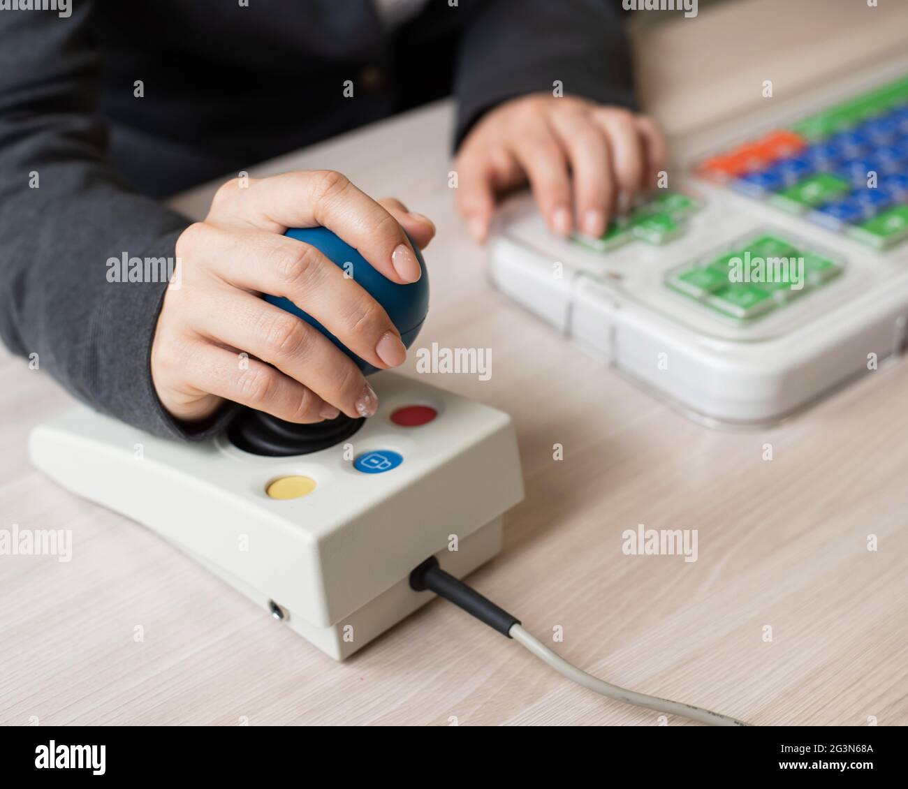 An unrecognizable woman with cerebral palsy is typing on the keyboard ...