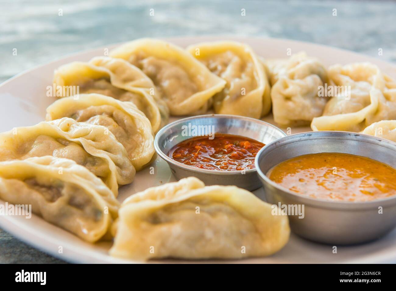 Plate of traditional momos served with tasty dipping Stock Photo - Alamy