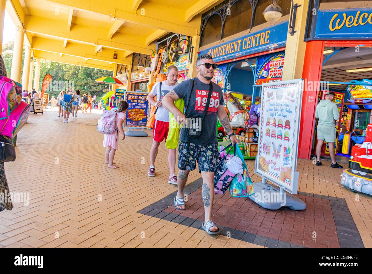 Crowds enjoying a sunny summer’s day walk along Barry Island promenade ...