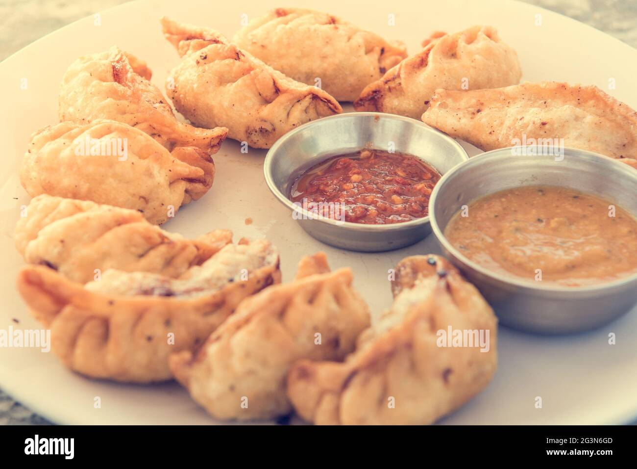 Plate of traditional momos served with tasty dipping Stock Photo - Alamy