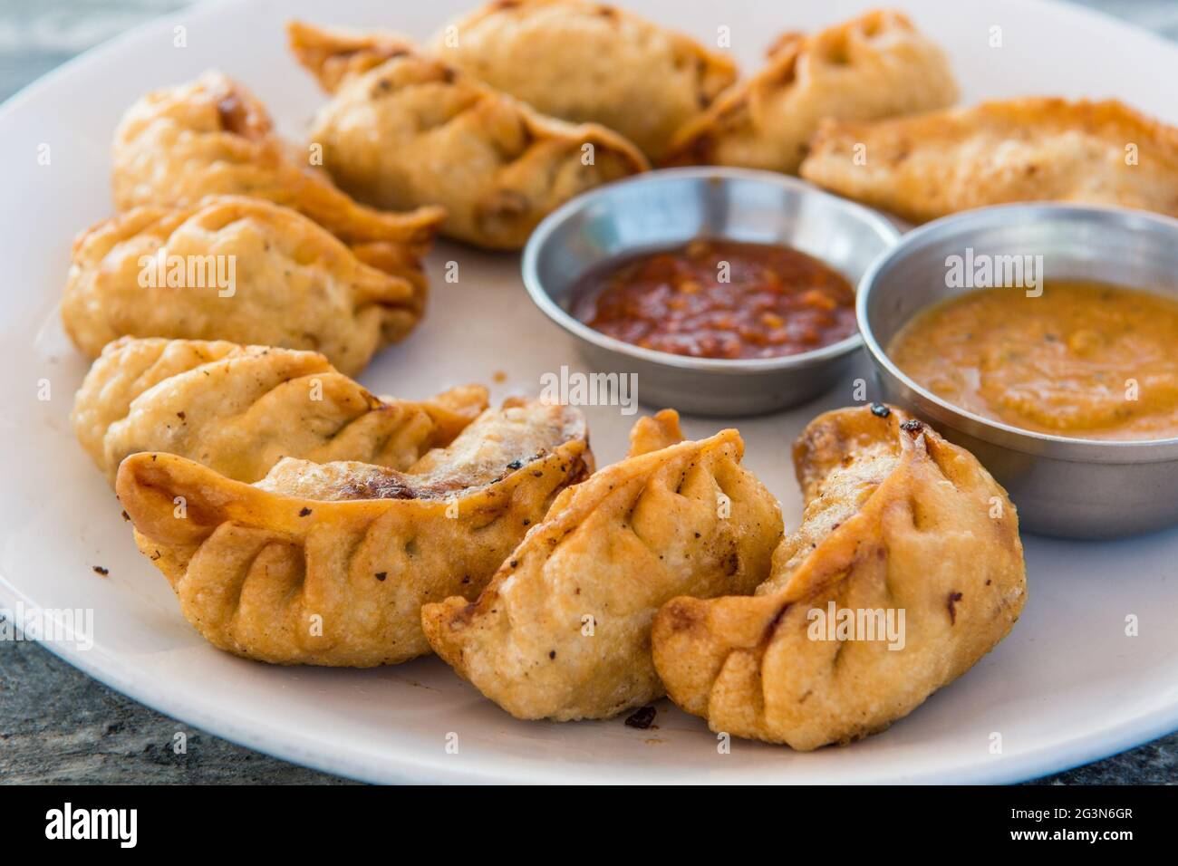 Plate of traditional momos served with tasty dipping Stock Photo - Alamy