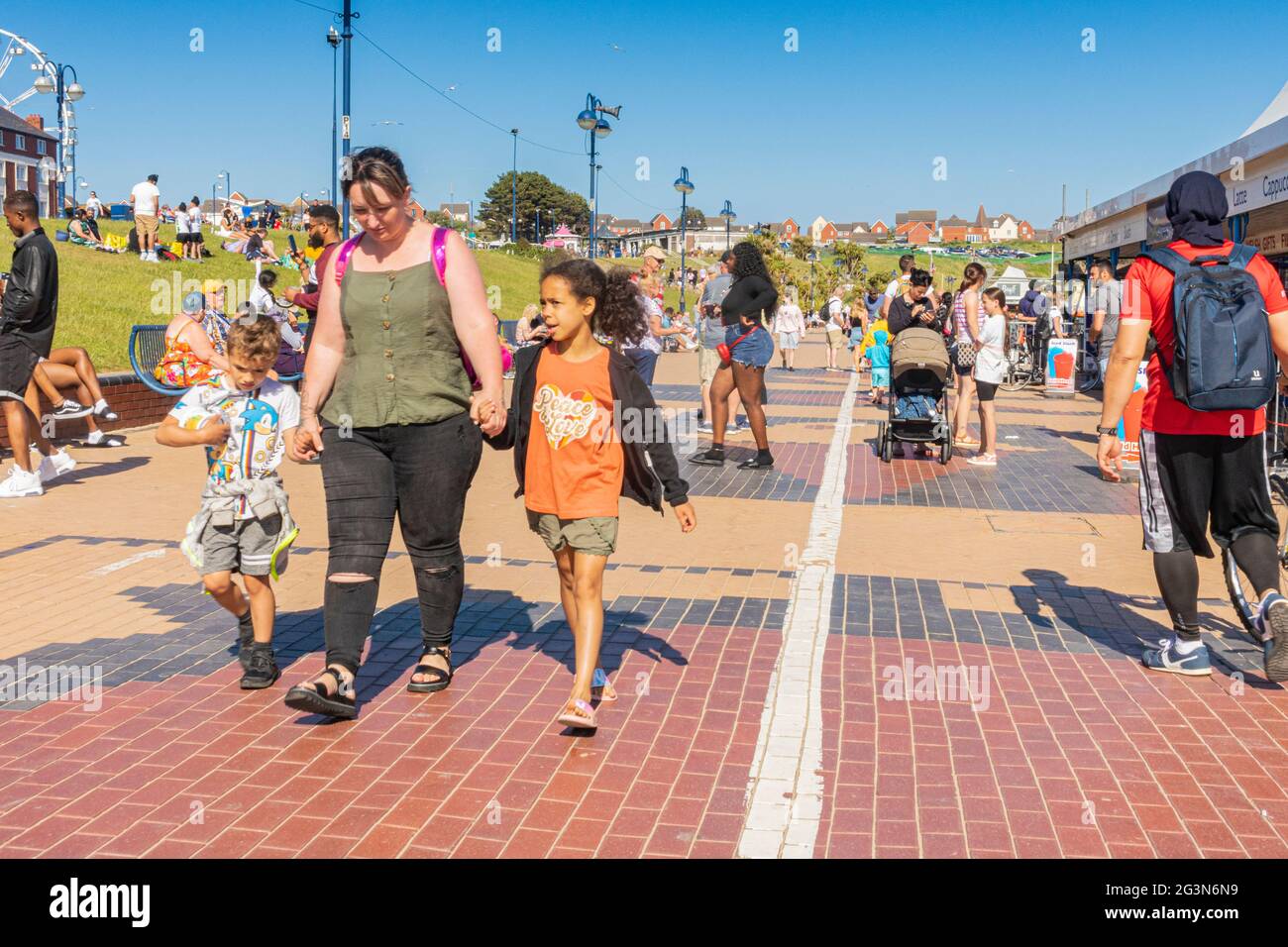 Crowds enjoying a sunny summer’s day walk along Barry Island promenade ...