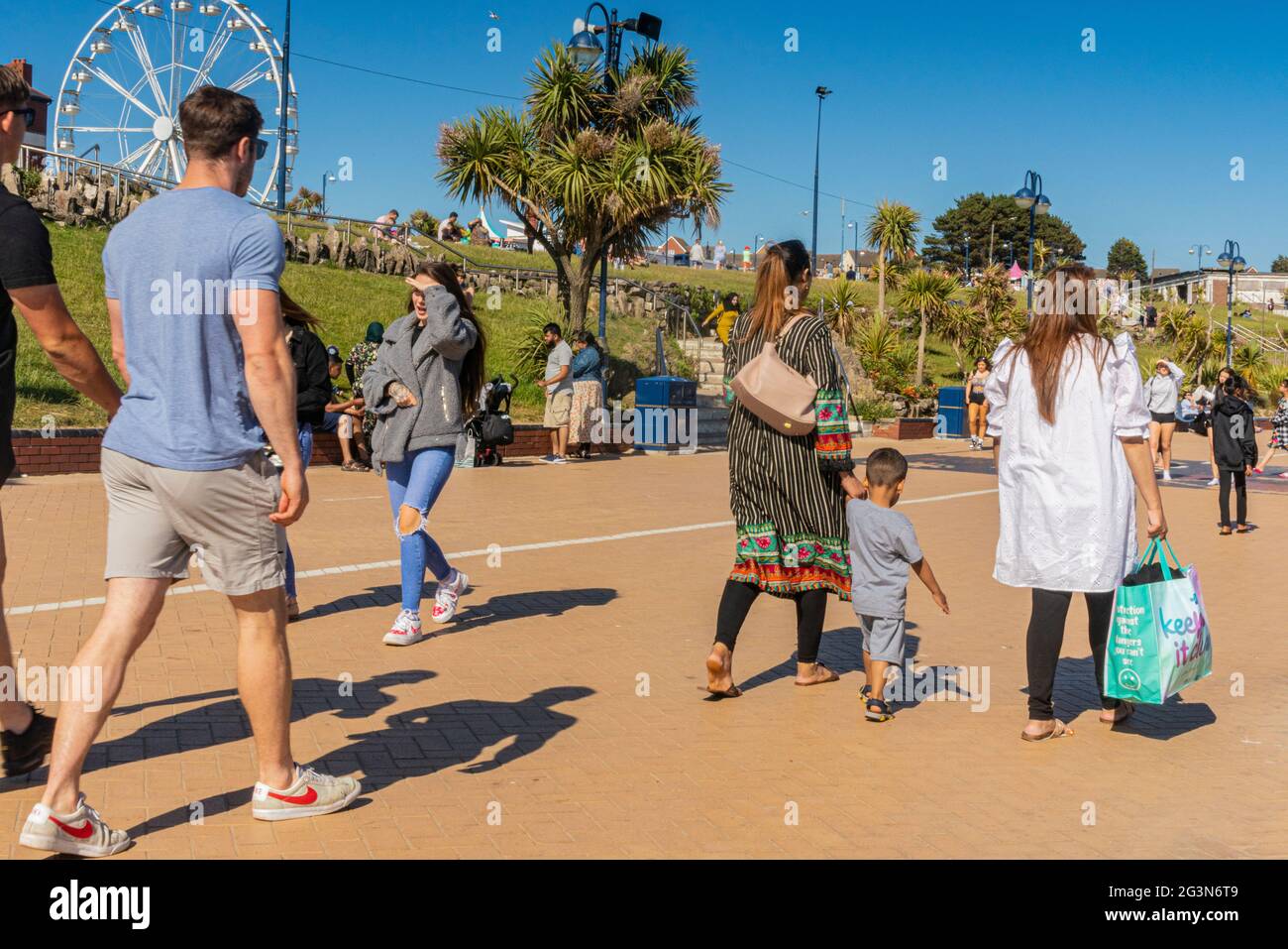 Crowds enjoying a sunny summer’s day walk along Barry Island promenade ...