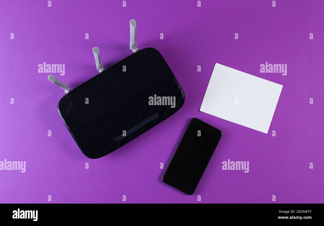 Three antenna wi-fi router with smartphone on a purple background. Copy ...